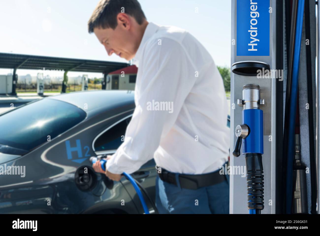 Man holds a hydrogen fueling nozzle on a hydrogen filling station ...