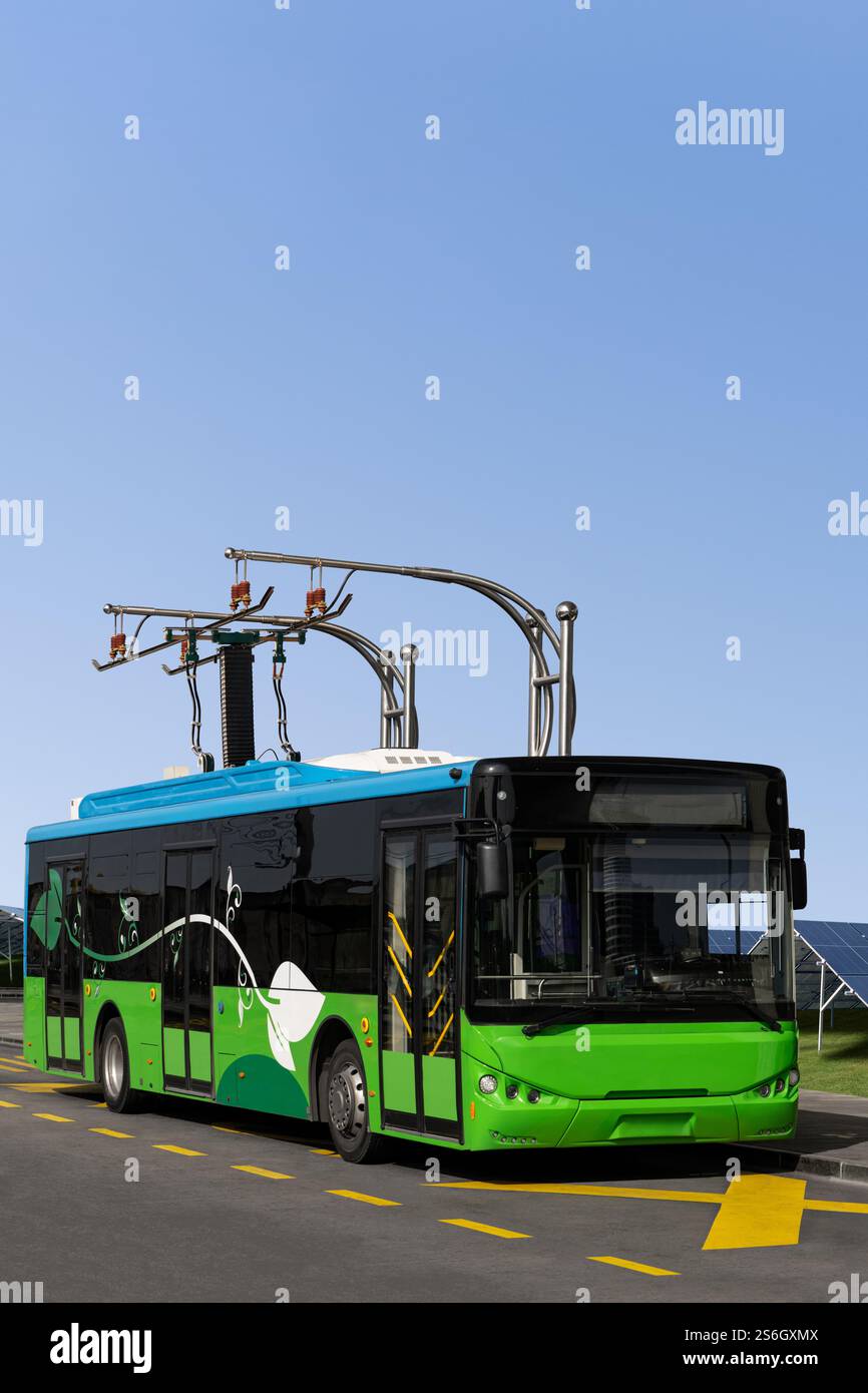 Electric bus at a stop is charged by pantograph. Sola panels in the background Stock Photo - Alamy
