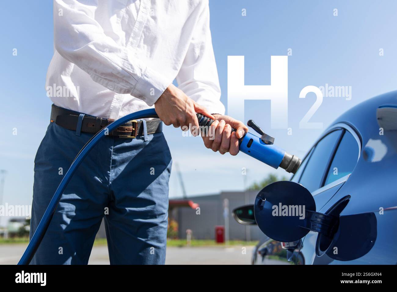 Man holds a hydrogen fueling nozzle on a hydrogen filling station ...