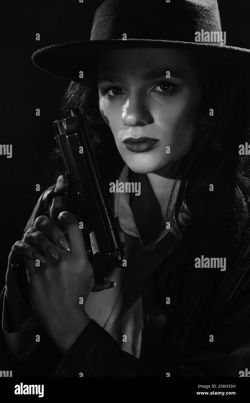 Silhouette of a female detective in a coat and hat with a gun in her ...