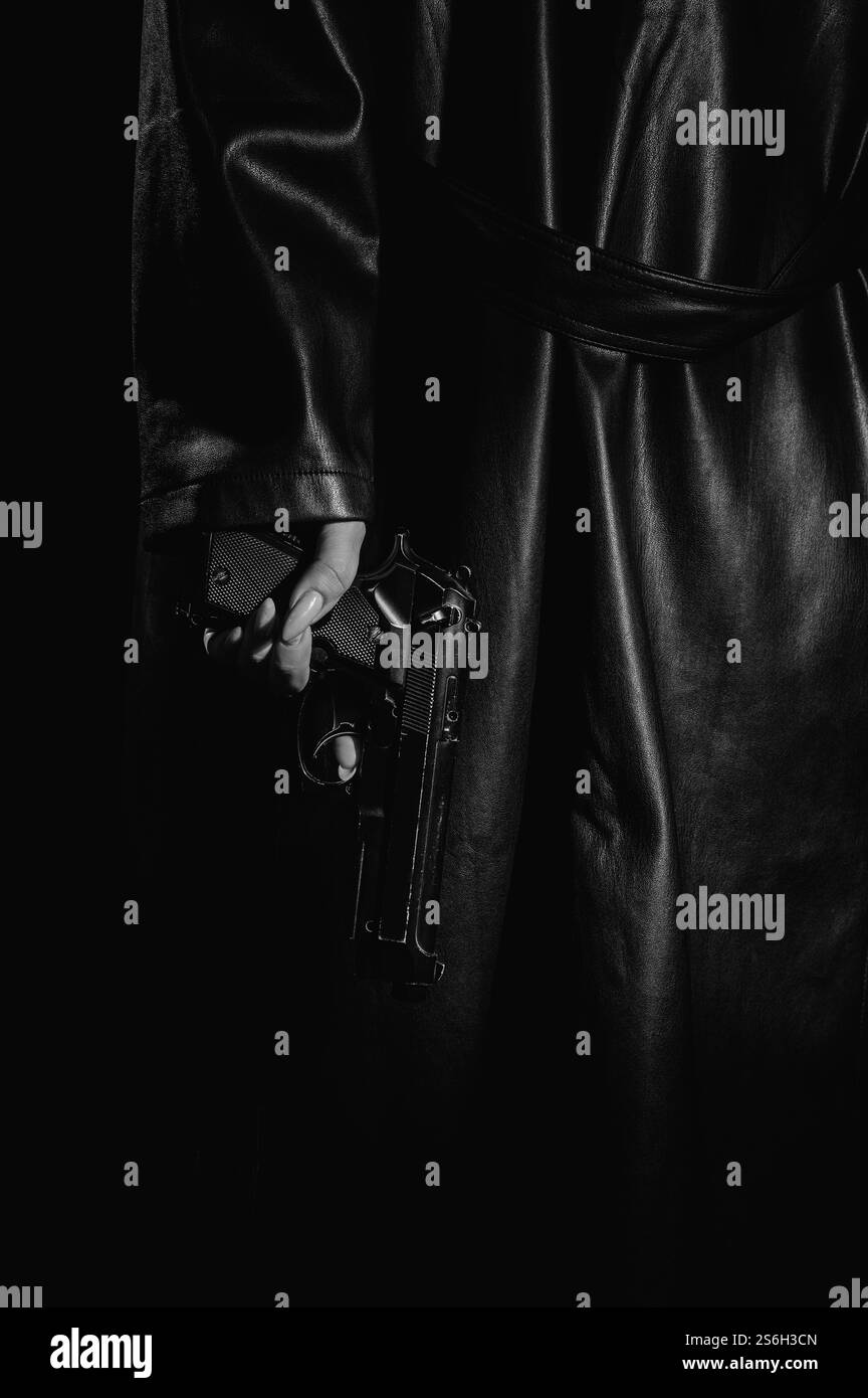 The silhouette of a female detective in a coat with a gun in her hands, which she hides behind ...