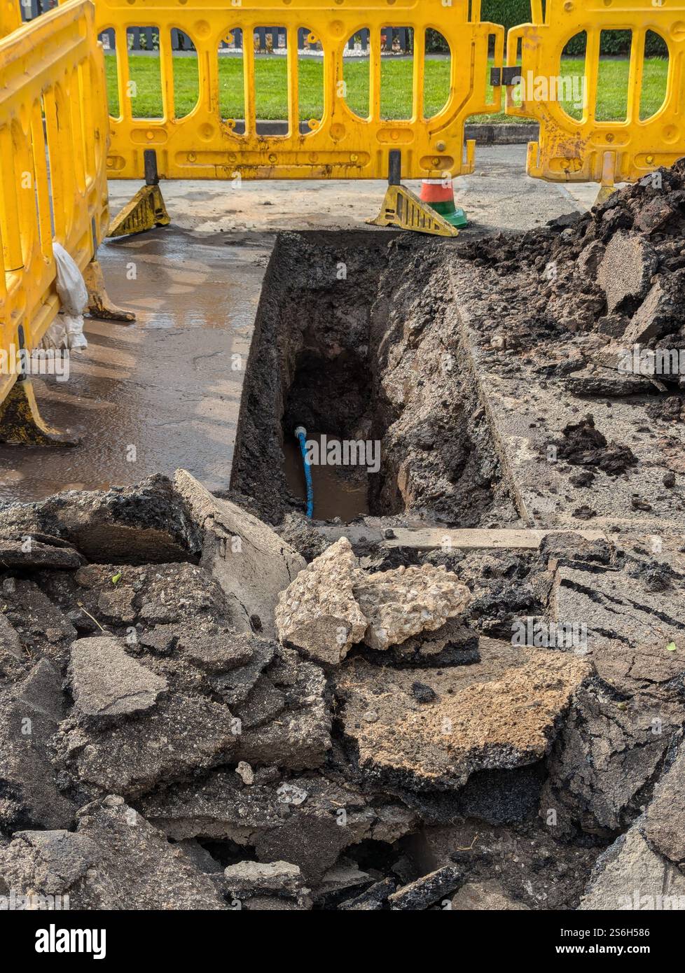 A hole in a road dug out to fix a leaking pipe Stock Photo - Alamy