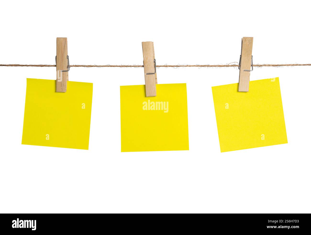 Three bright yellow sticky notes are clipped to a string with wooden ...