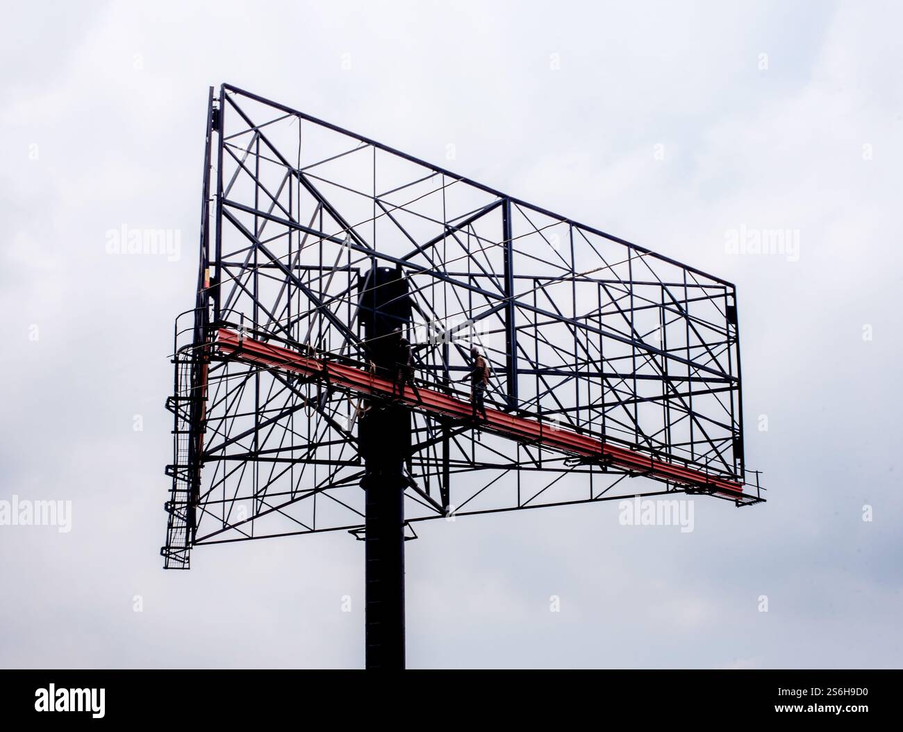 Two men work on a blank large billboard in Ibadan, Oyo State, Nigeria ...