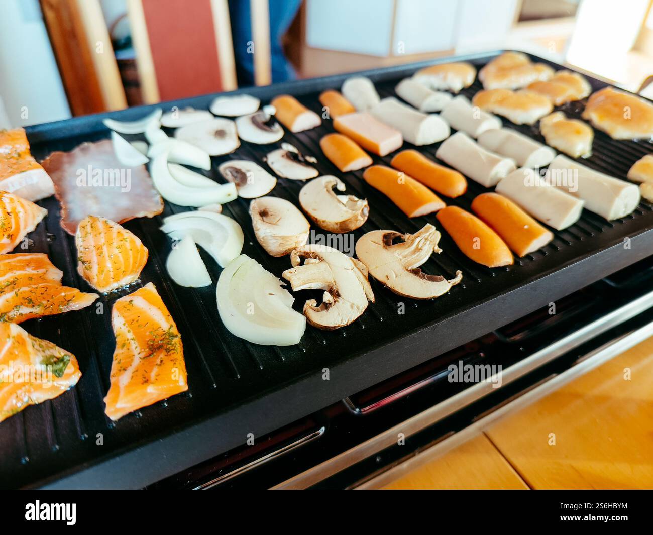 A flat griddle displays an assortment of grilled salmon, fish ...