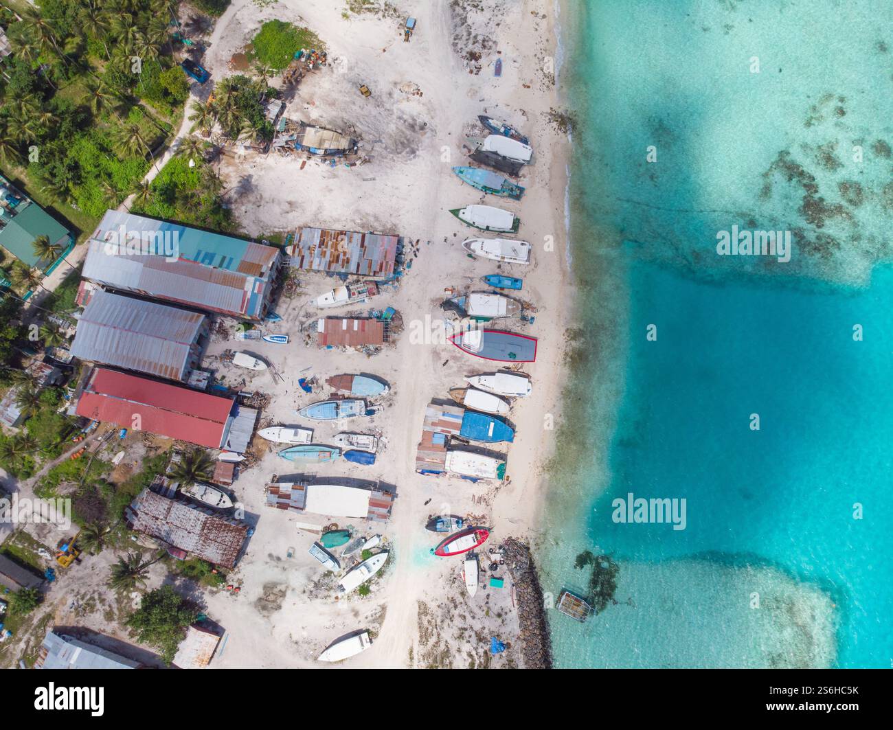 Aerial view of a Maldives island featuring a beach and lagoon, dotted ...