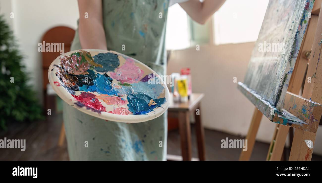 Focused artist presenting a colorful palette while preparing to paint ...