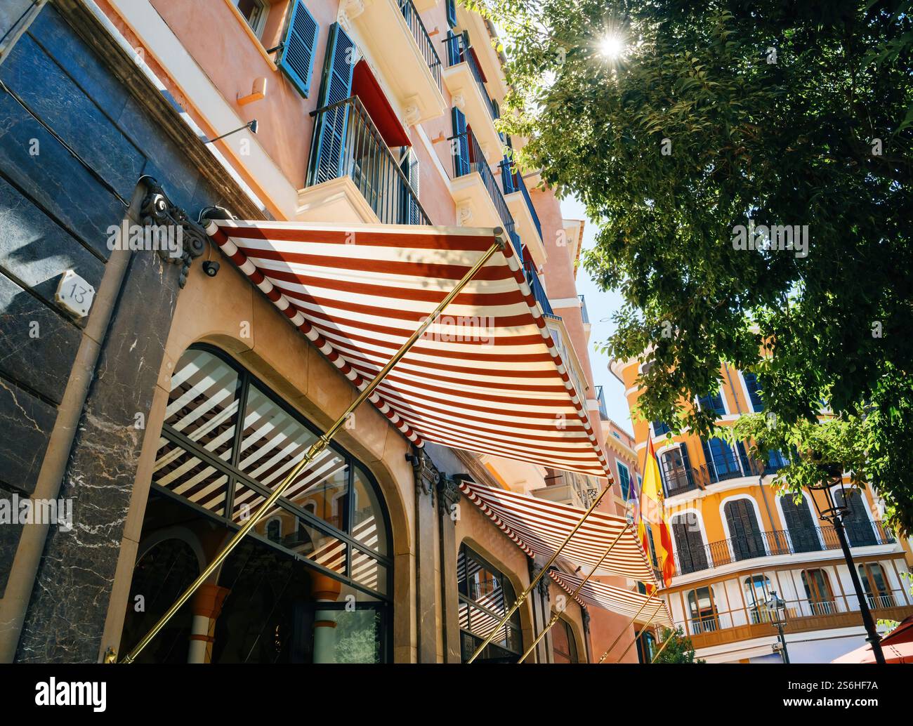 Vibrant street view in Mallorca with striped awnings, colorful ...