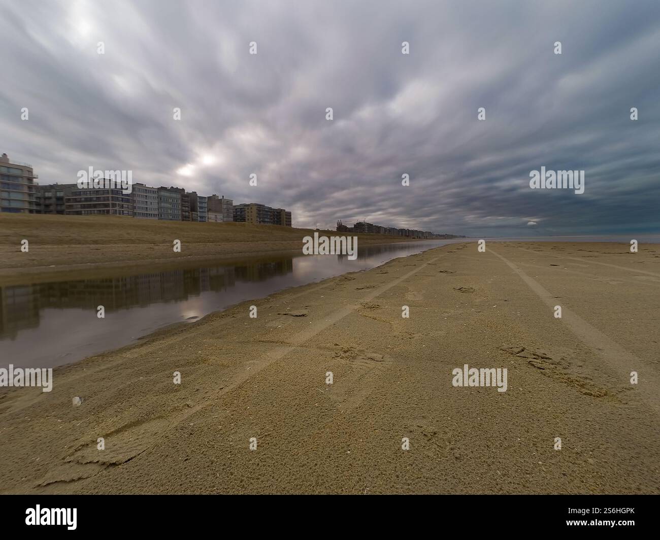A scenic beach landscape featuring a reflective water body, adjacent ...