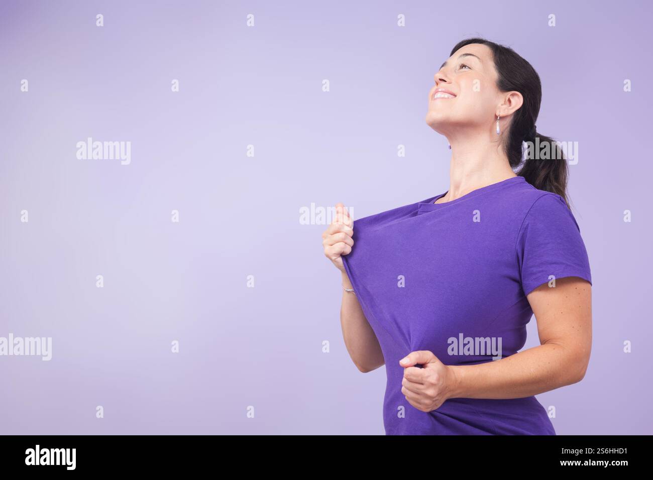 Woman in purple shirt smiles and lifts her shirt. Concept of confidence ...
