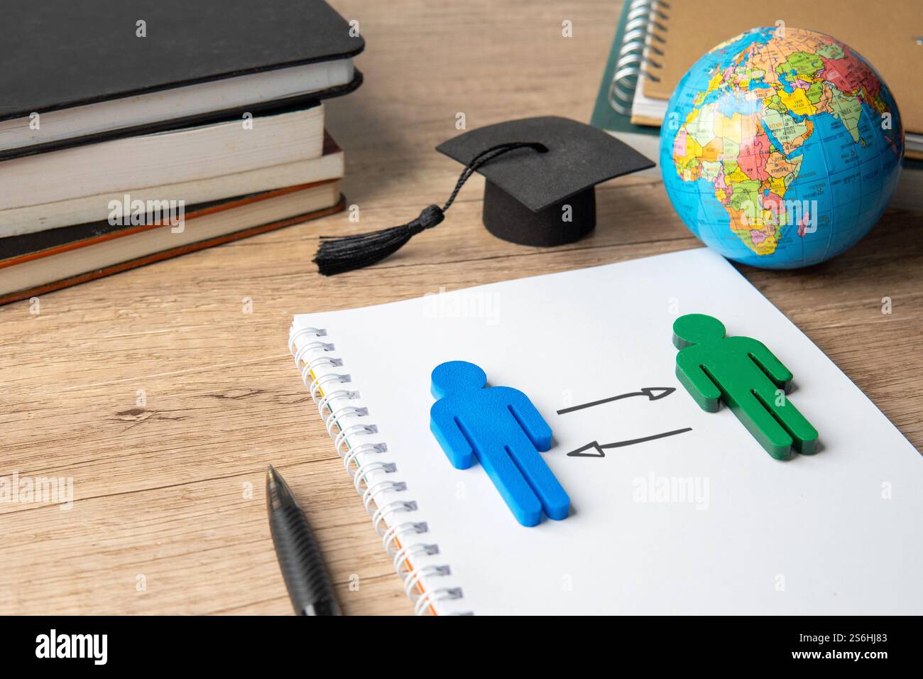 A graduation cap, a globe and two figures with arrows icon. Education ...