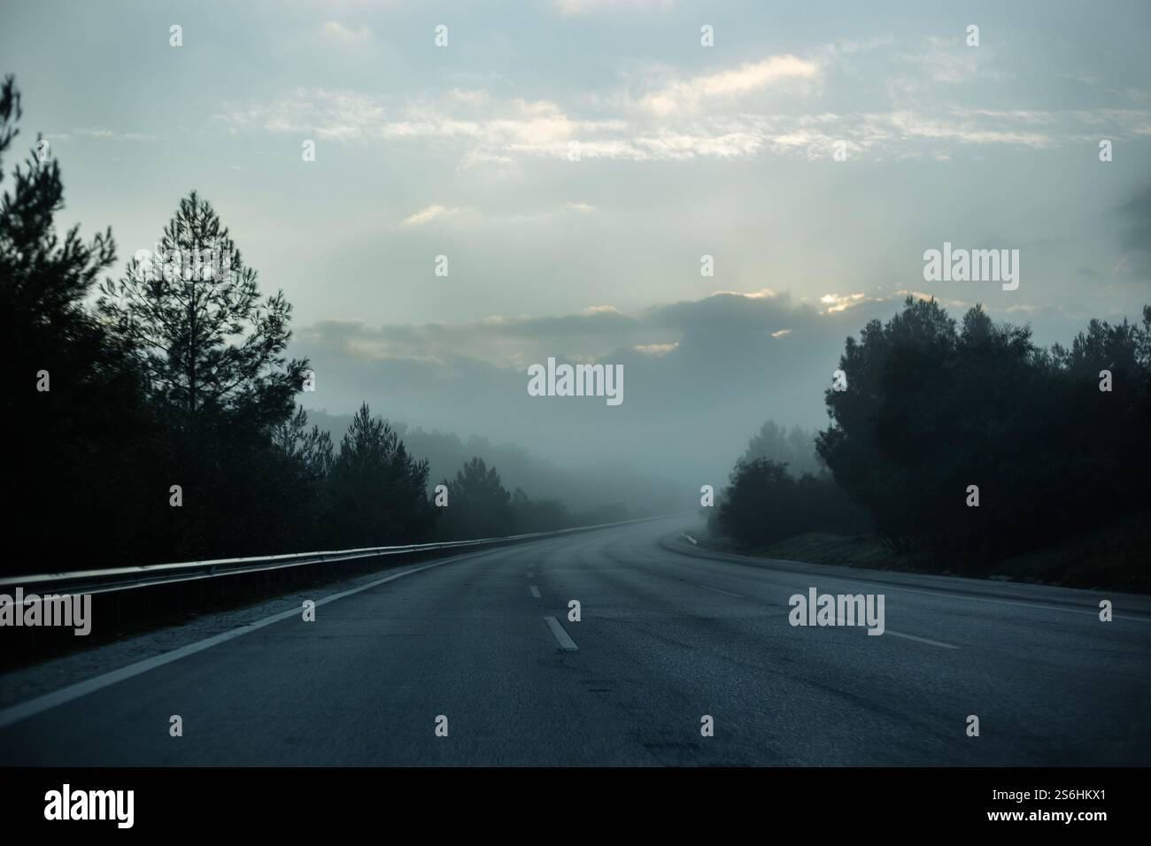 Foggy road at dawn, highway at a misty morning Stock Photo - Alamy