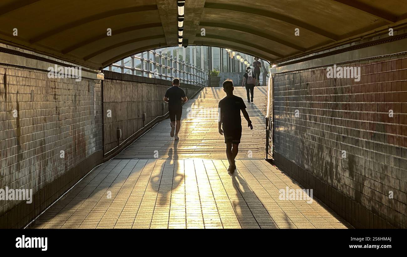 Pedestrian tunnel at sunrise along Clarke Quay area river Stock Photo ...