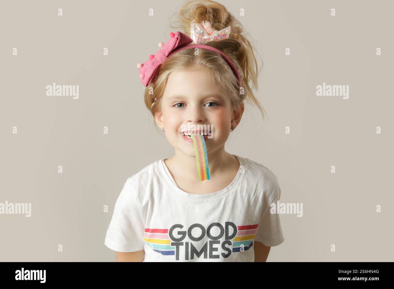 Adorable little girl eating sweet and sour colorful candy strip Stock ...