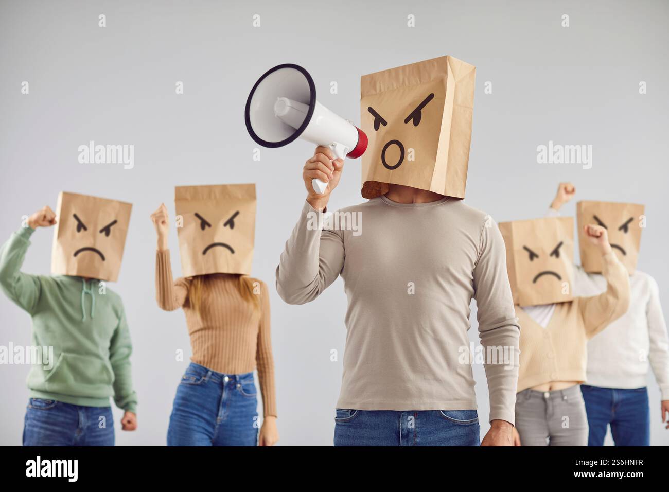 Man in paper bag mask on head shouting in megaphone with angry crowd of ...