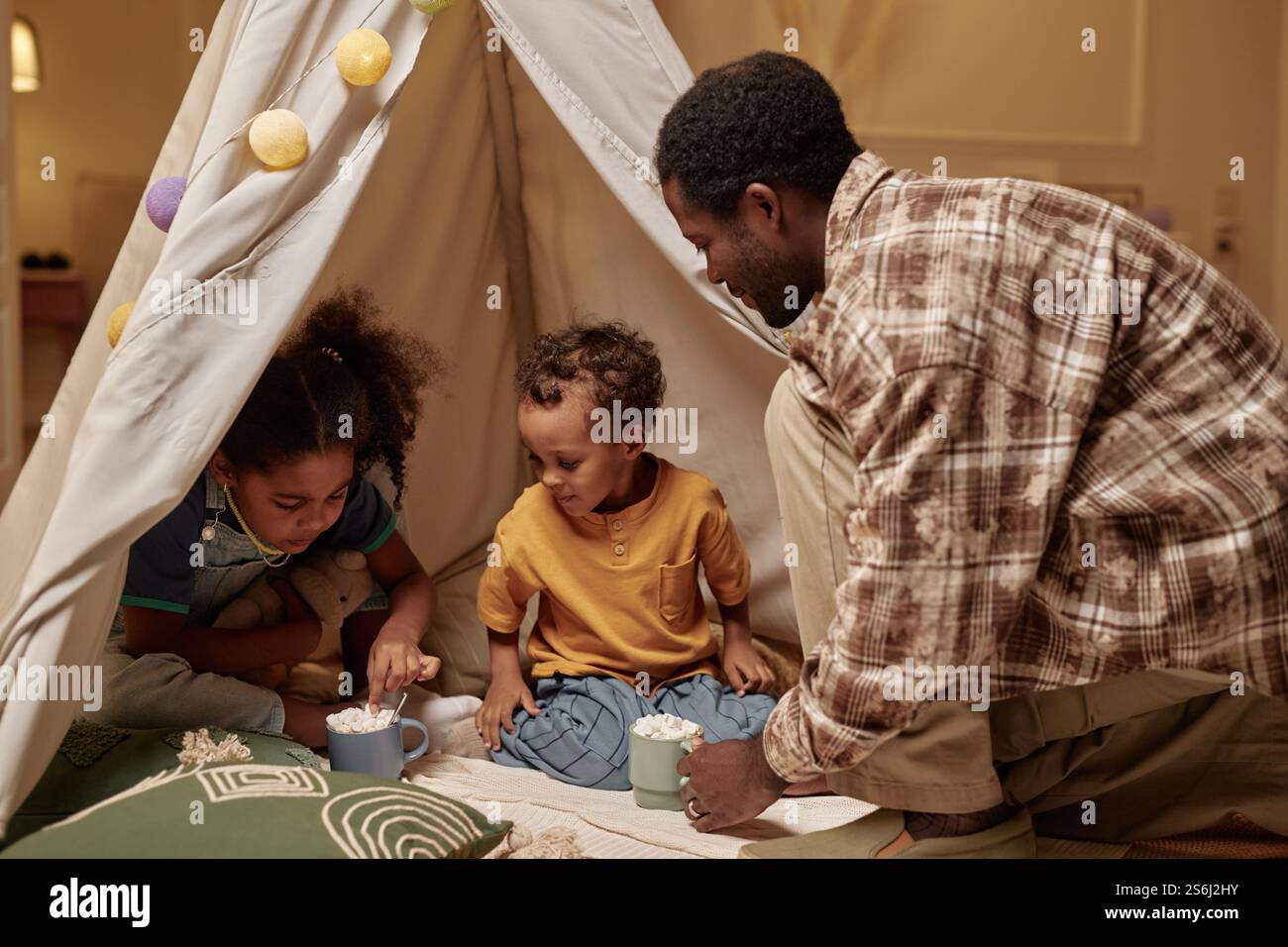 Caring African American father treating little kids to hot chocolate ...