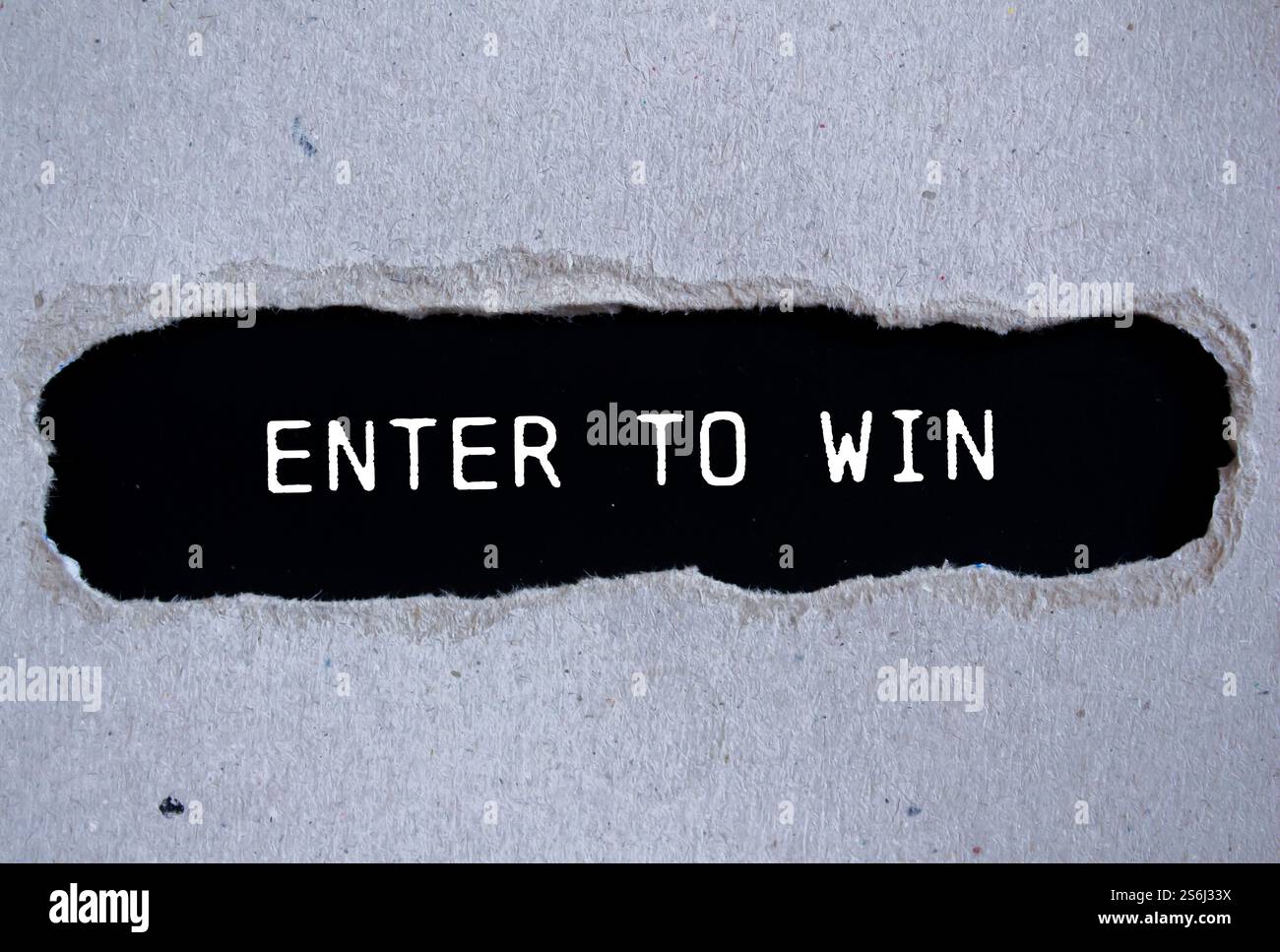 Enter to win message written on ripped torn gray paper with black ...