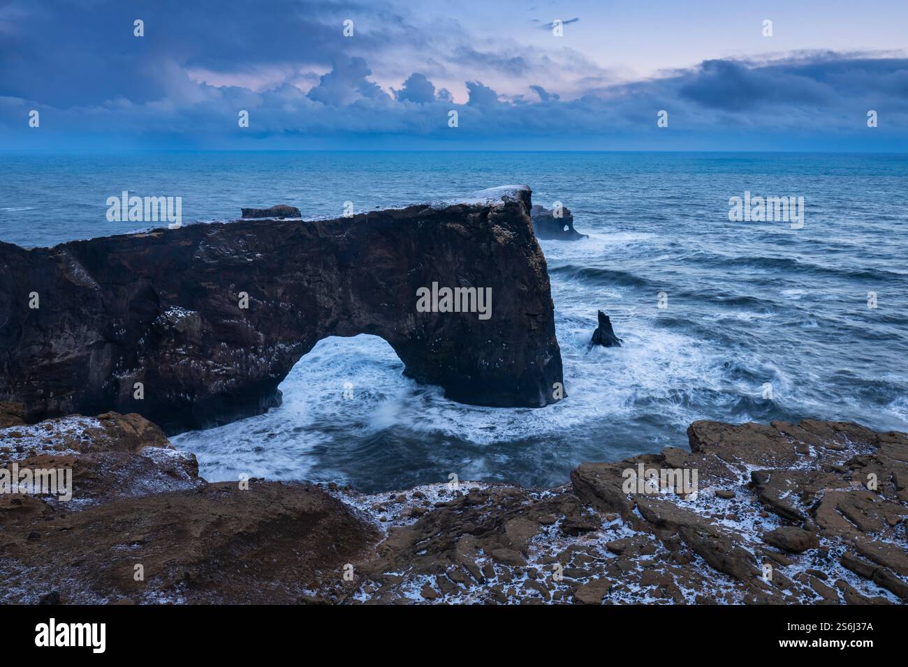 View of the Dyrhólaey arch and cliff at blue hour. Vík í Mýrdal ...