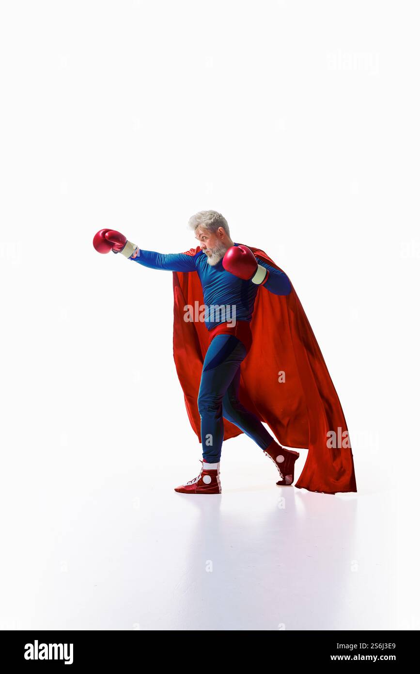 Dynamic image of man in superhero costume with red cape delivering ...