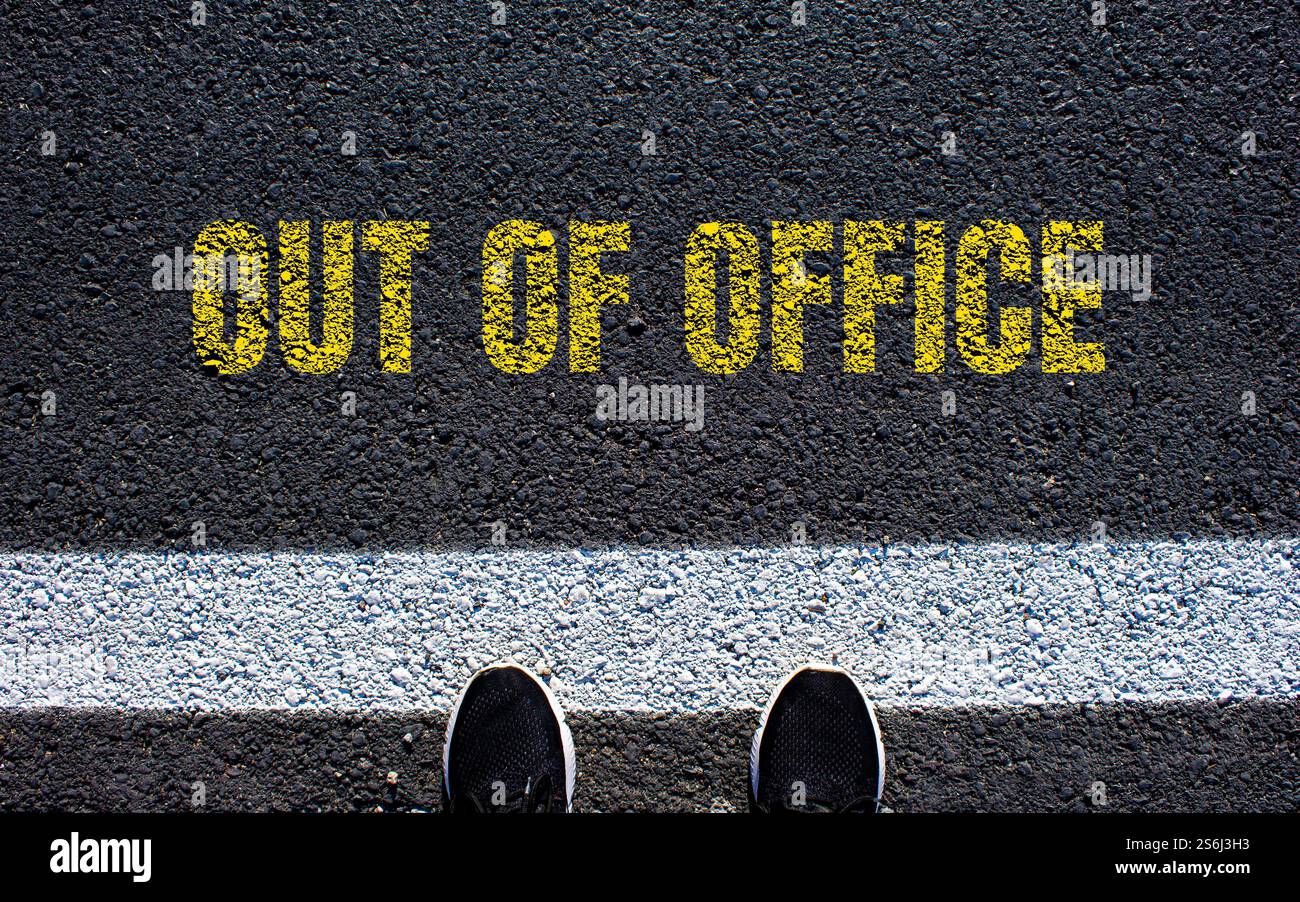 Out of office message written on asphalt road. Conceptual out of office ...