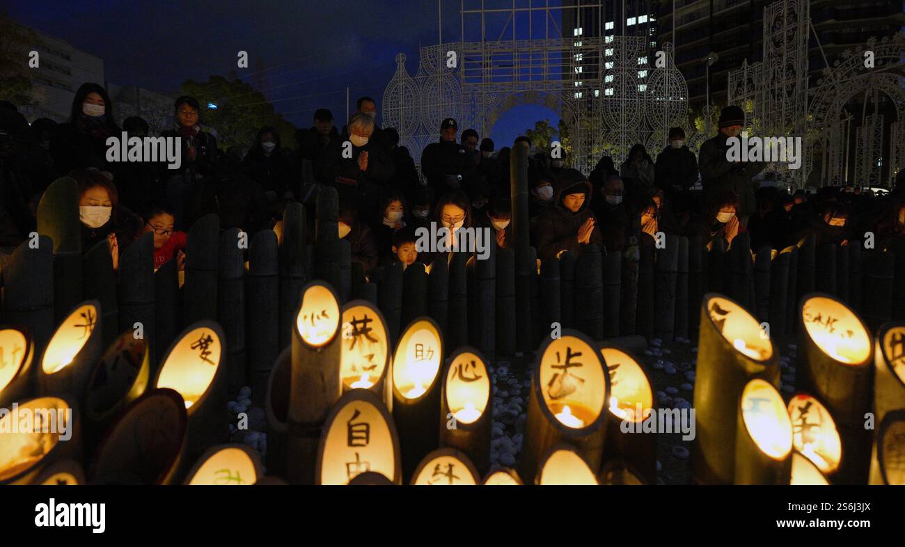 People pray during a memorial ceremony at a park in Kobe, Hyogo ...