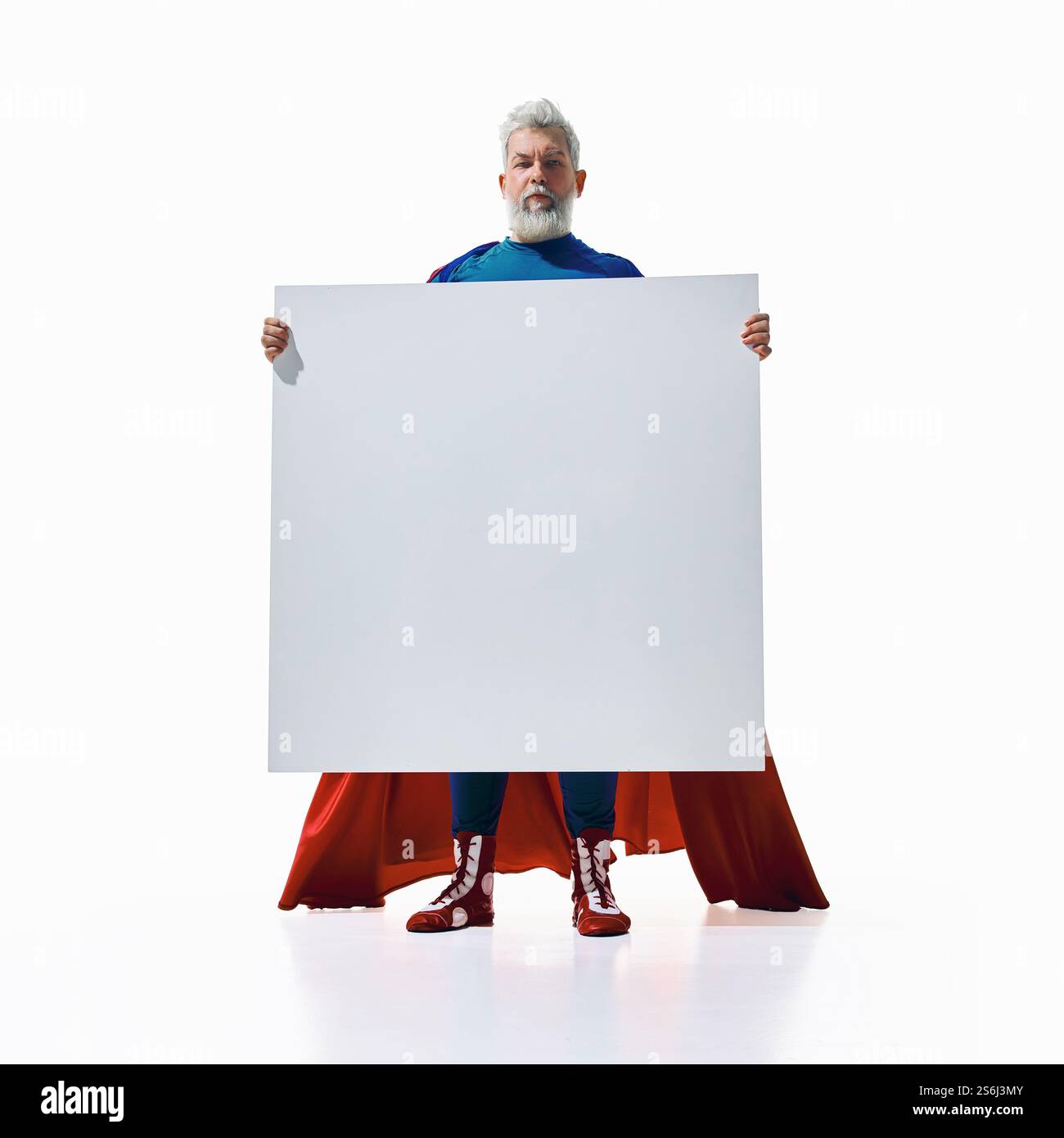 Serious Grey-haired man in superhero costume with red cape standing ...