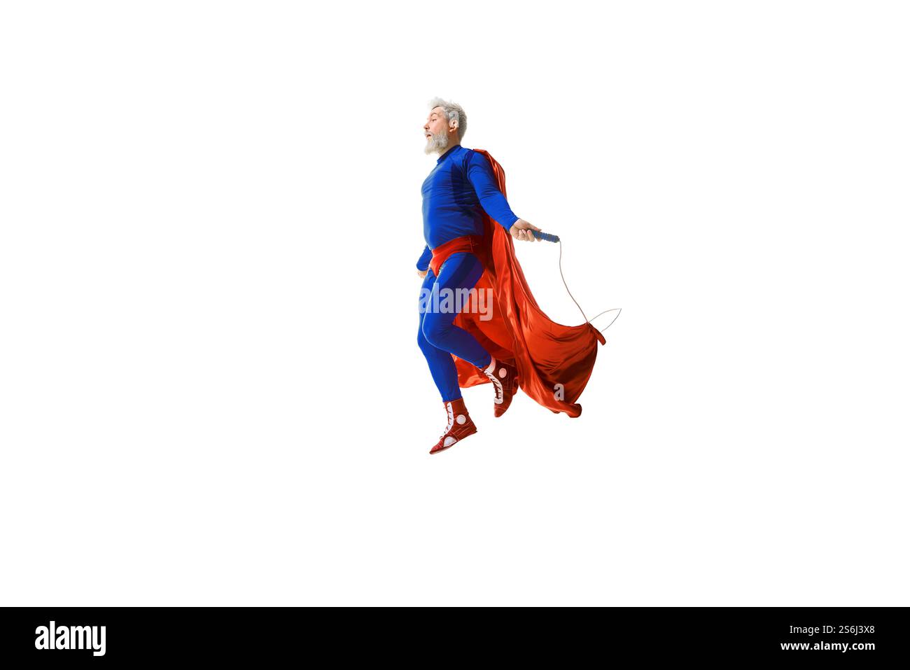 Man in blue superhero costume with red cape training, jumping rope ...