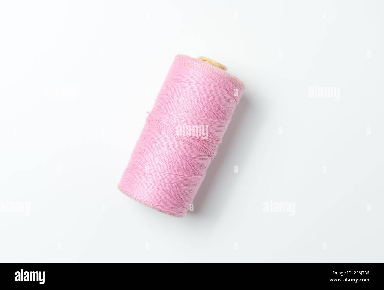 Pink thread spool on white background Stock Photo - Alamy