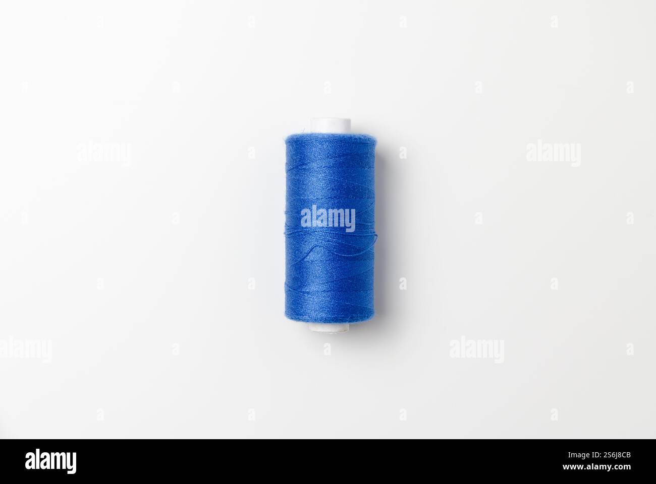 Blue thread spool on white background Stock Photo - Alamy