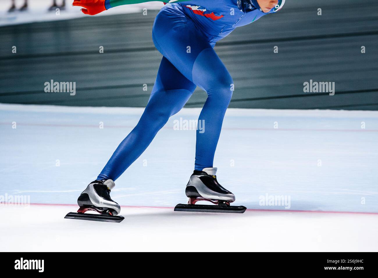 male speed skater at speed skating competition in light-dark background ...