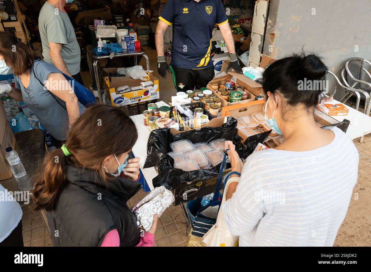 People in need taking food in a free food distribution point after DANA ...