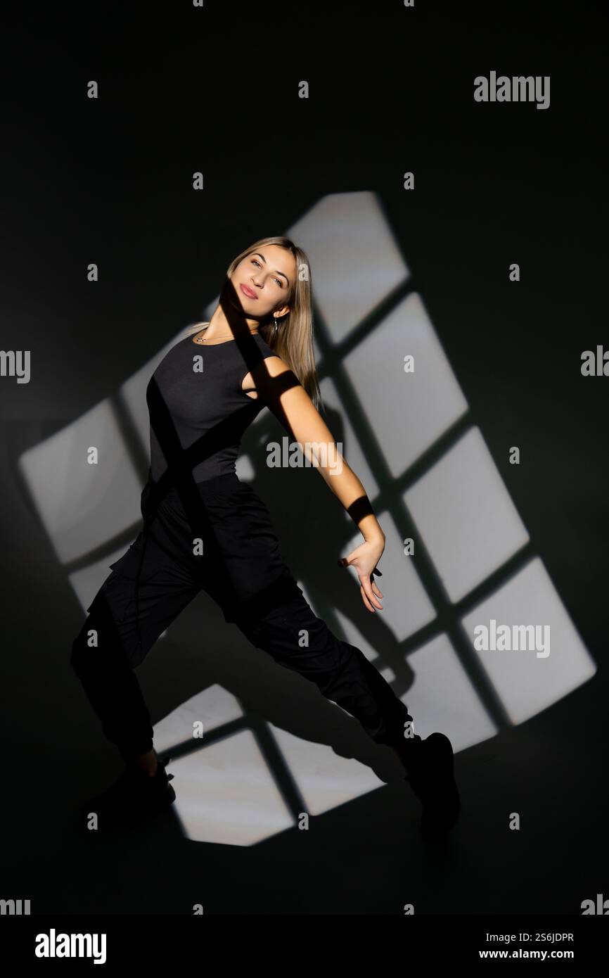 Female dancer posing with window-shaped shades projected on the ...