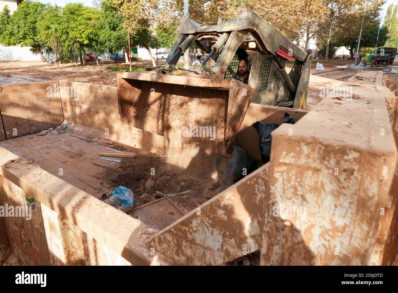 Mini excavator bobcat driver operator transporting debris to a big ...