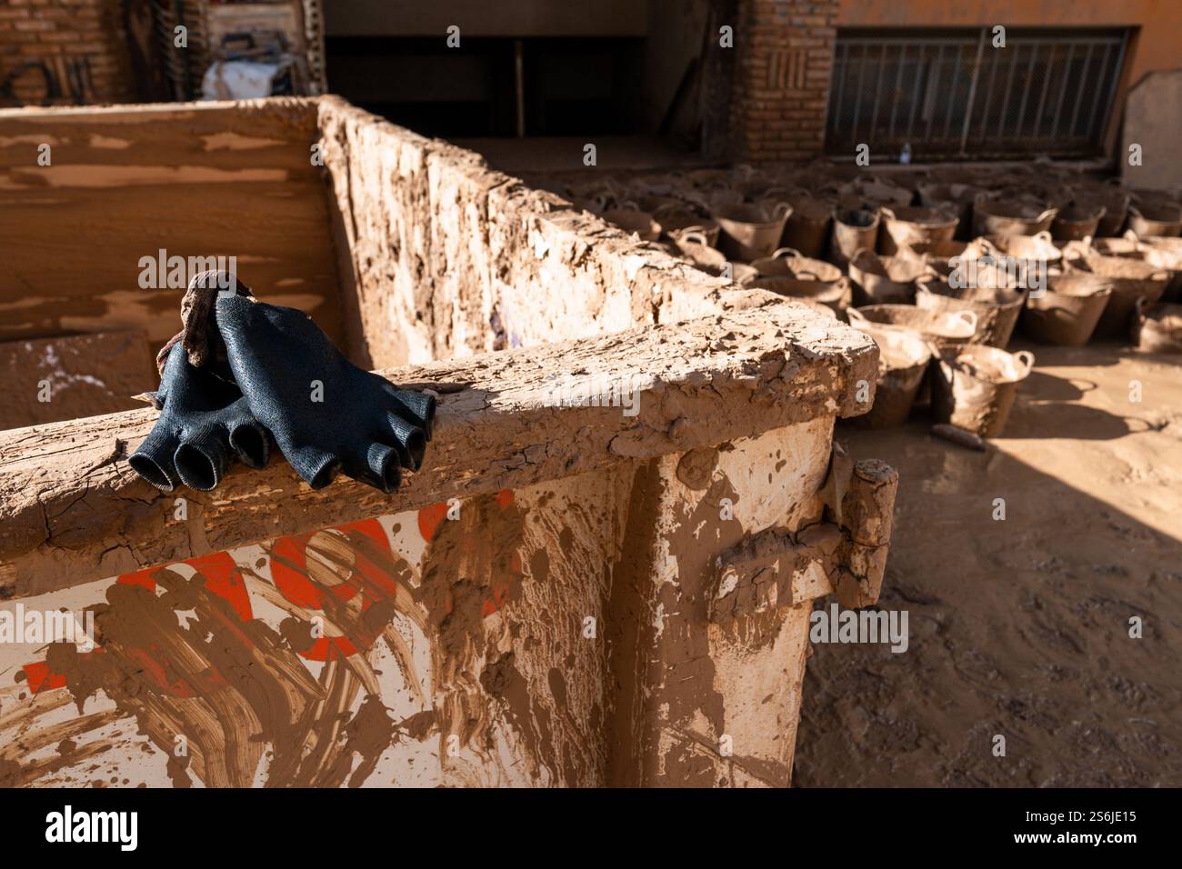 Street covered in mud with dumpster container and buckets full of mud ...