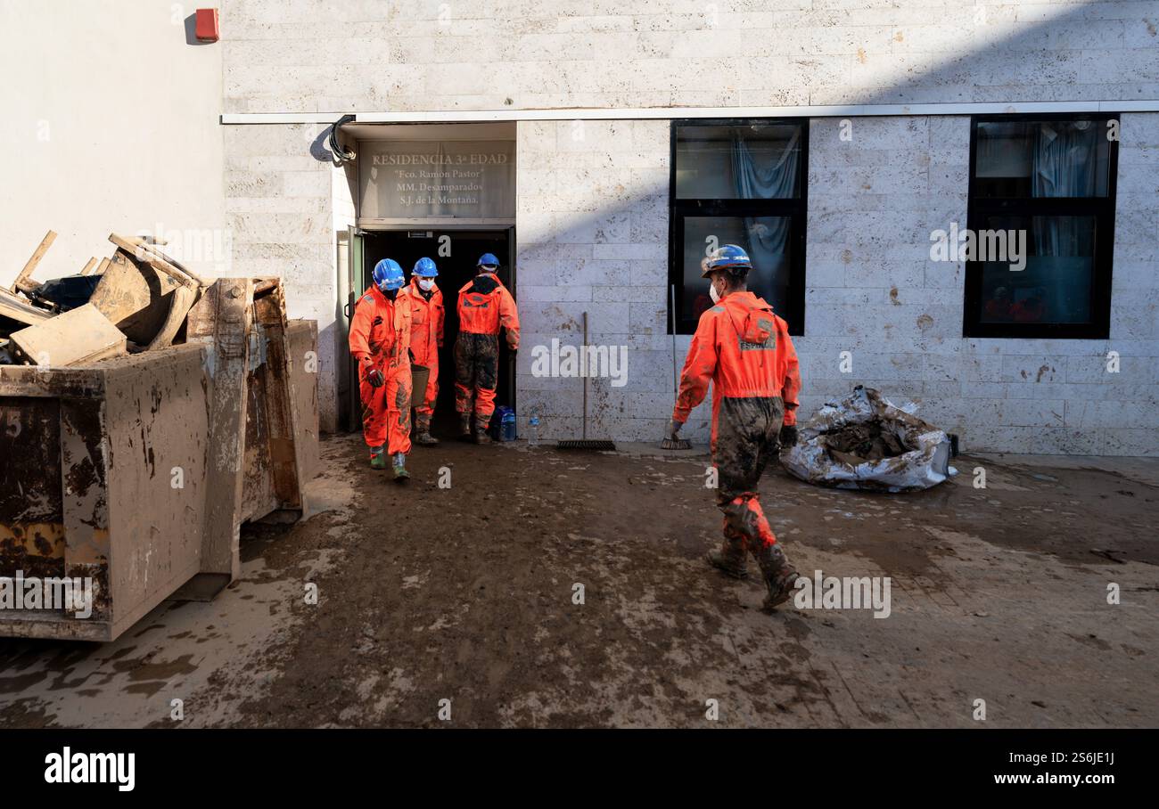 Spanish Army members in orange military jumpsuit cleaning a flooded ...