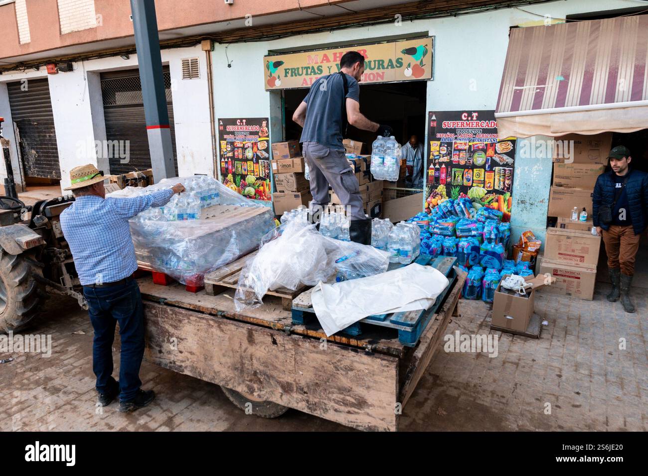 Residents of Catarroja bringing bottles of water to a grocery store ...