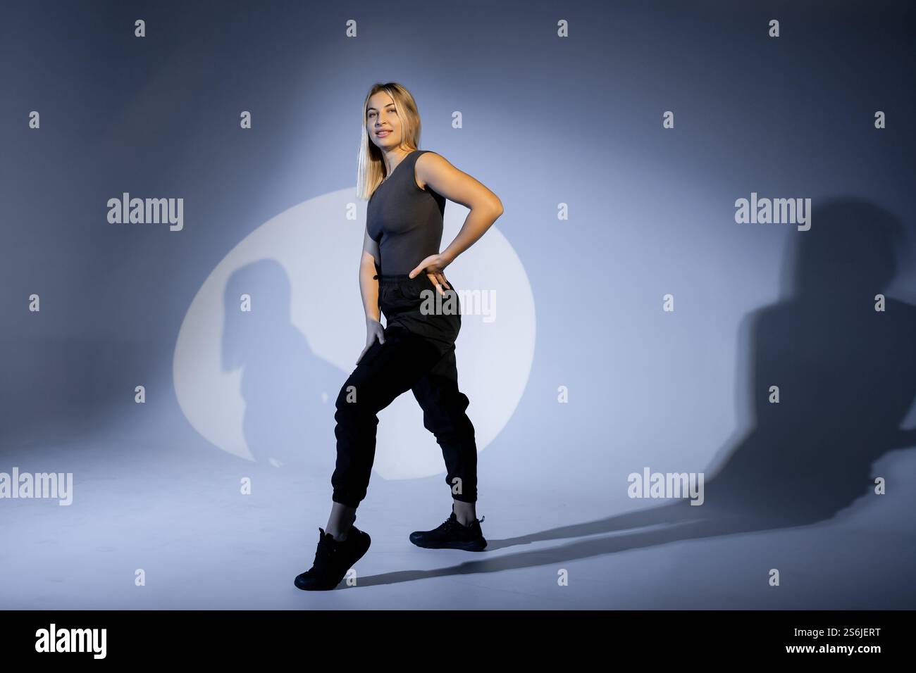 Young female dancer striking a pose under dramatic lighting, showcasing ...