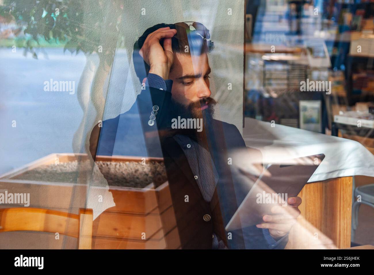 young businessman taking a break in a cafe - view through shop young ...