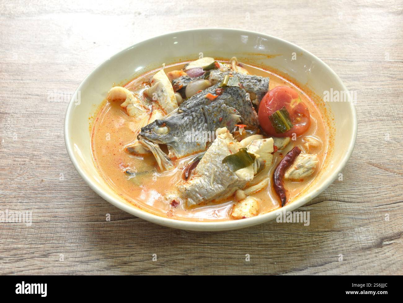 boiled bass fish head and mushroom in tom yum soup on plate Stock Photo ...