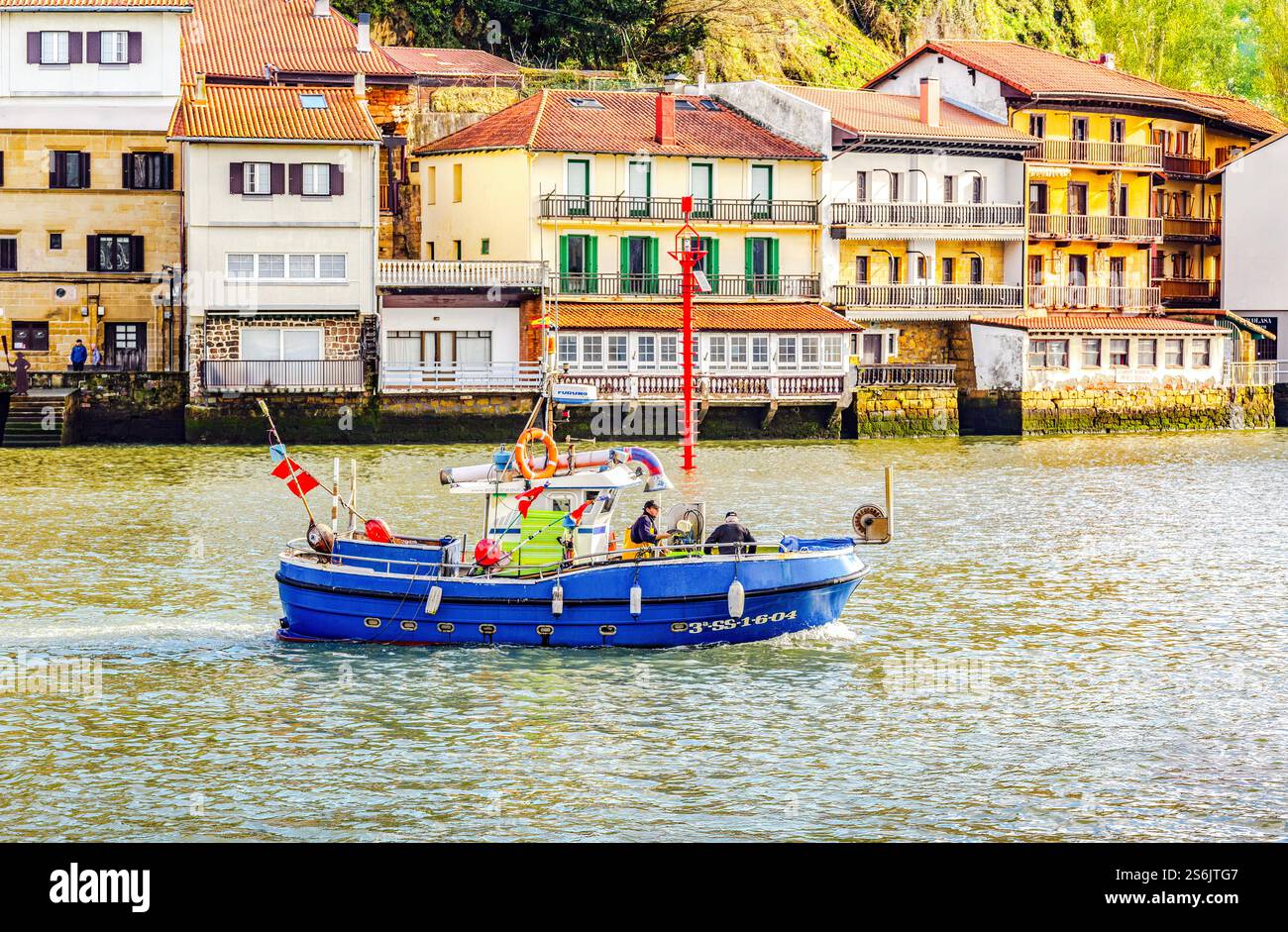 A fishing boat crossing the Pasajes Bay, in front of the fishing ...