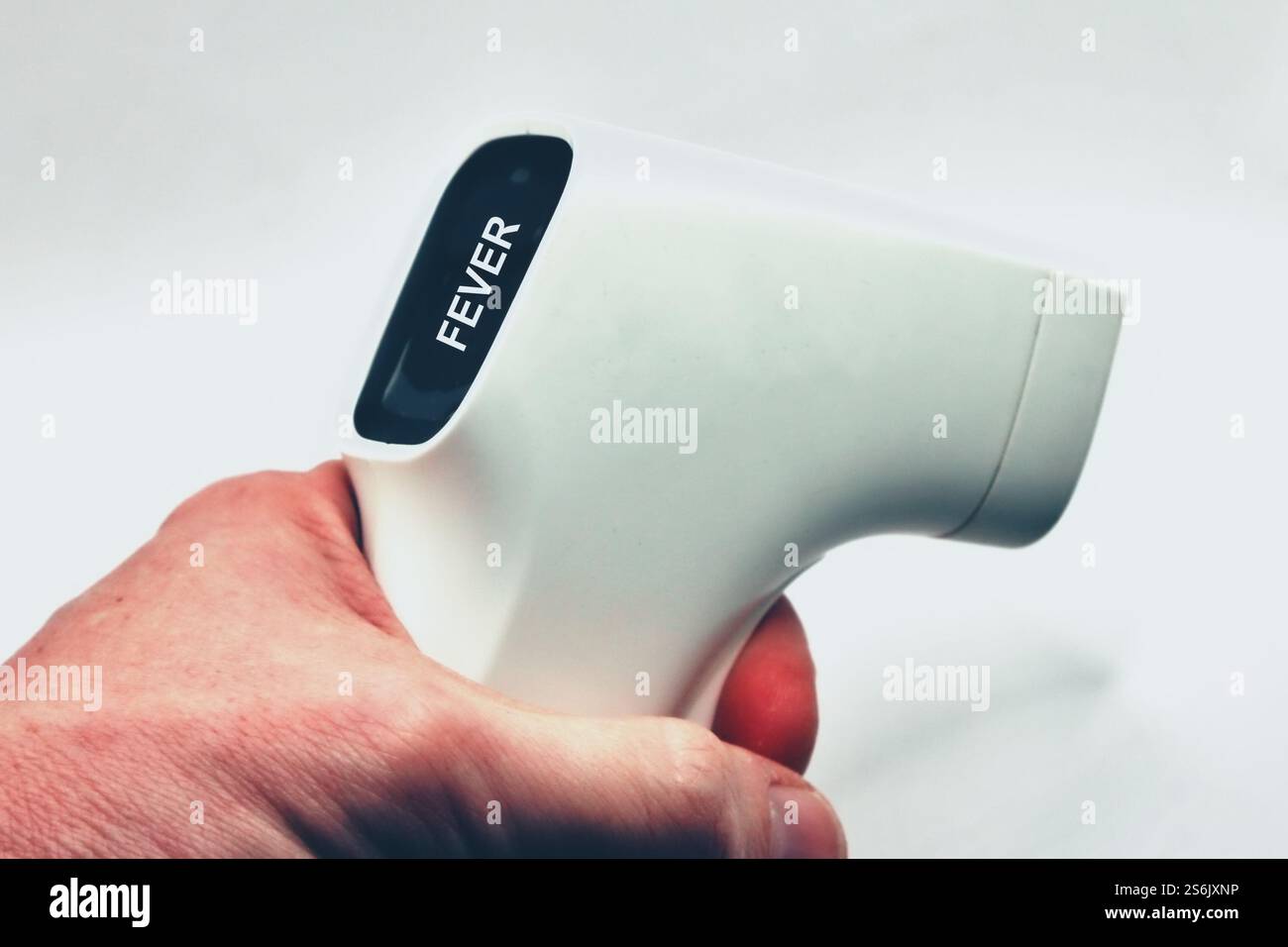 Hand with a gun thermometer with the sign "Fever Stock Photo - Alamy