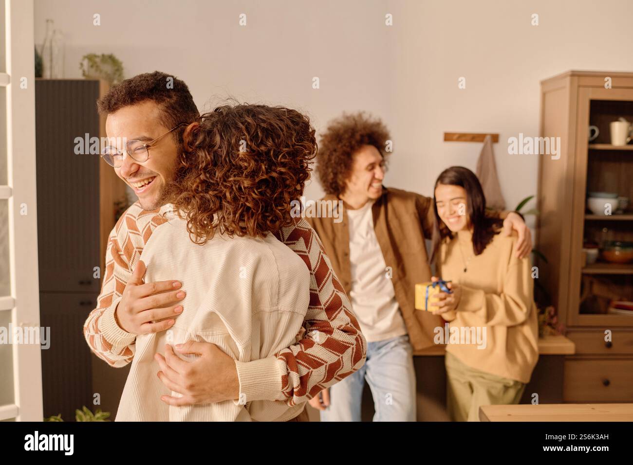 Medium close up of beaming young adult man hugging his female friend ...