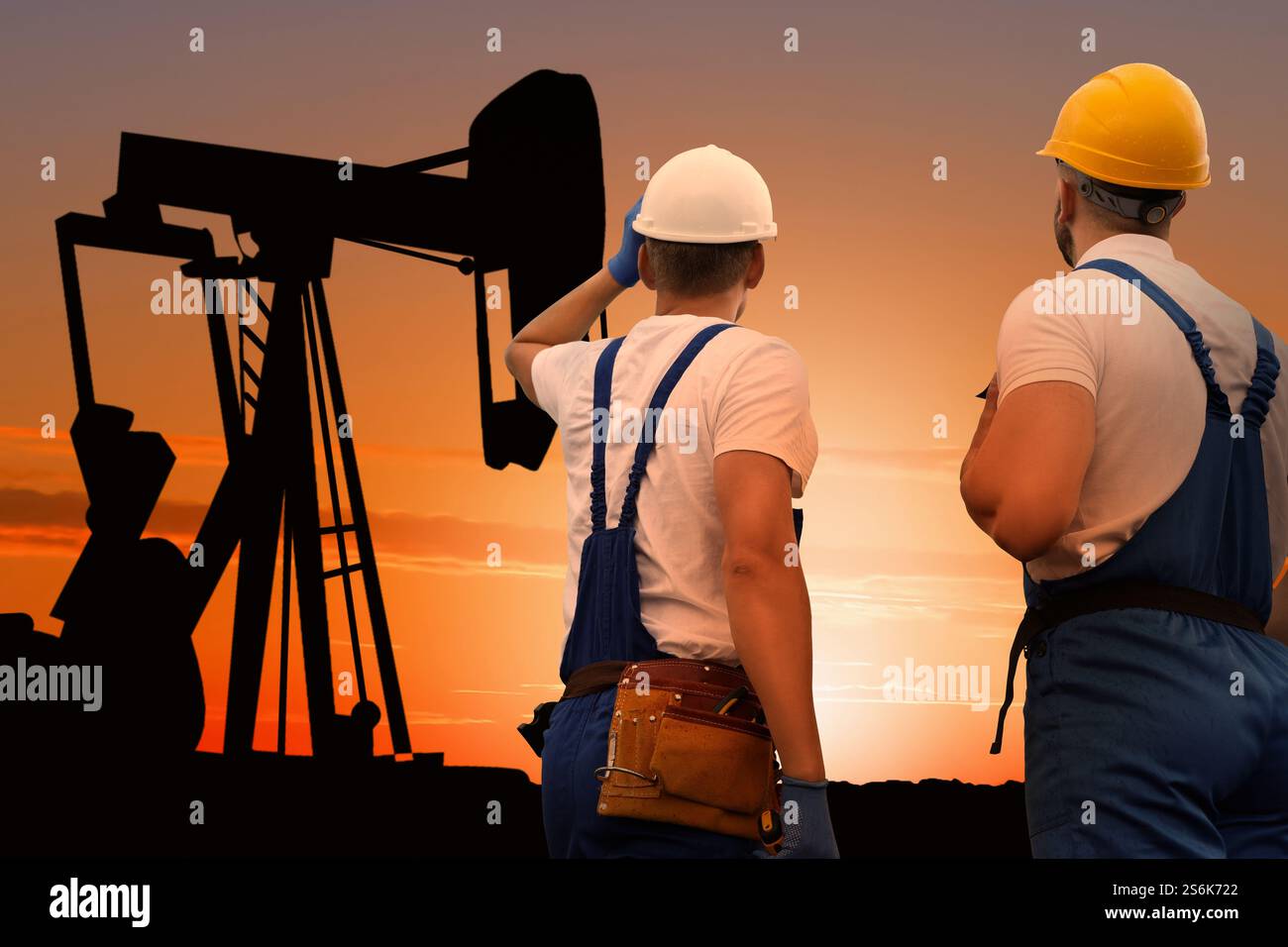 Workers at oil production site with crude oil pump Stock Photo - Alamy