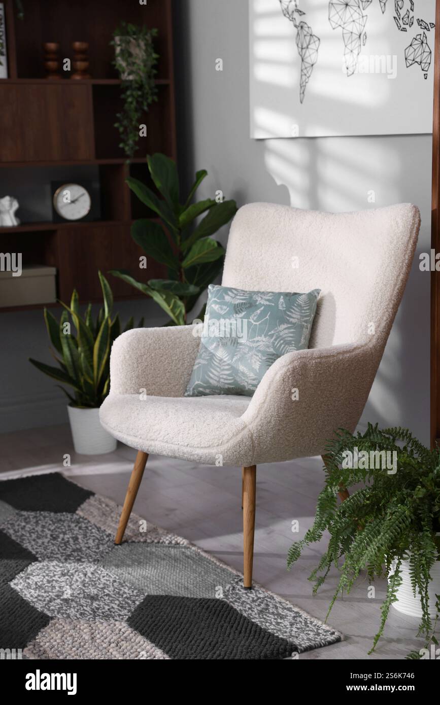 Stylish living room interior with soft white armchair Stock Photo - Alamy