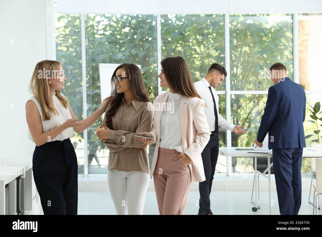 Office employees talking at workplace during break Stock Photo - Alamy