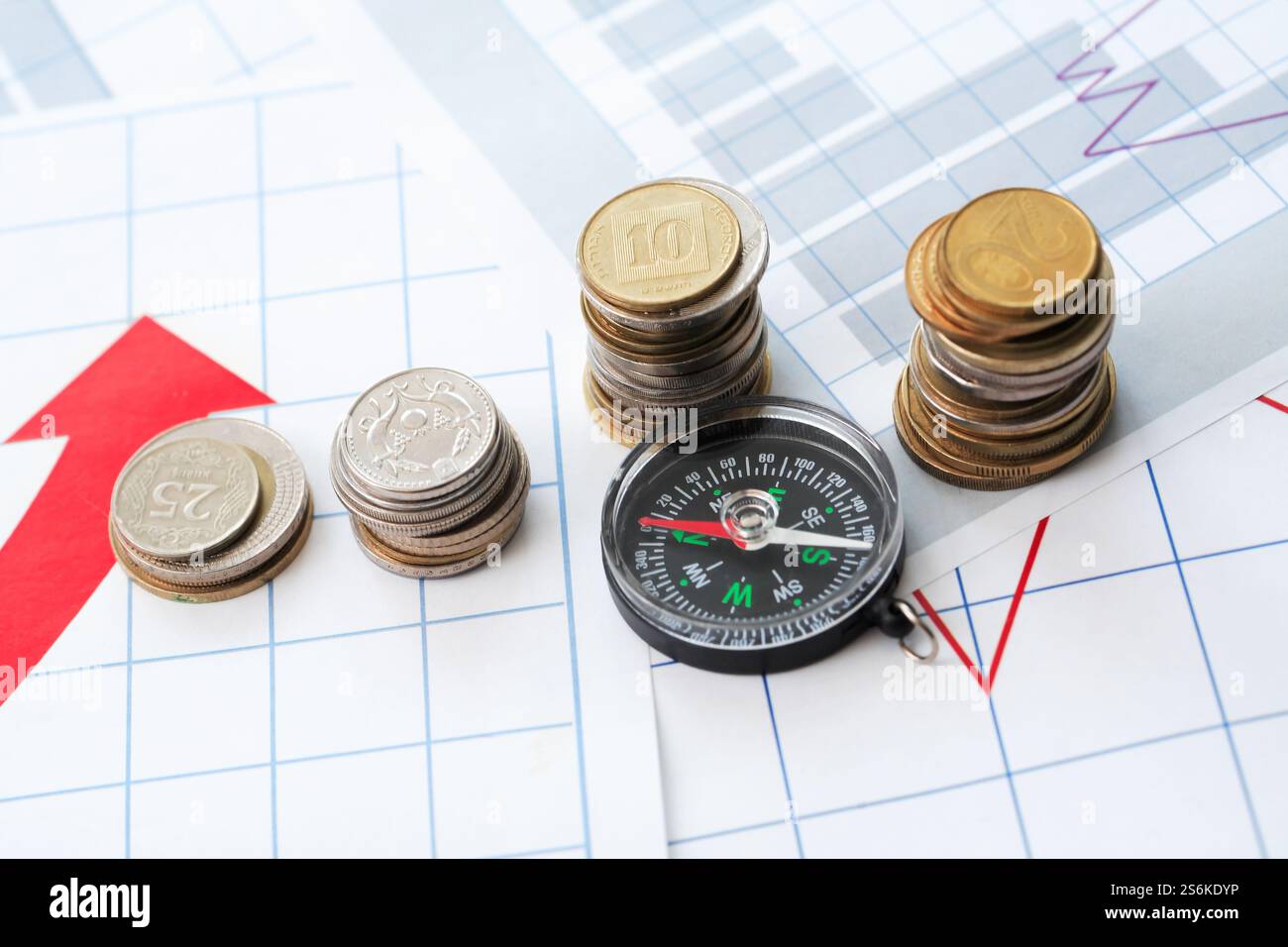 Business concept. Set of coins columns in a row and compass on diagram ...