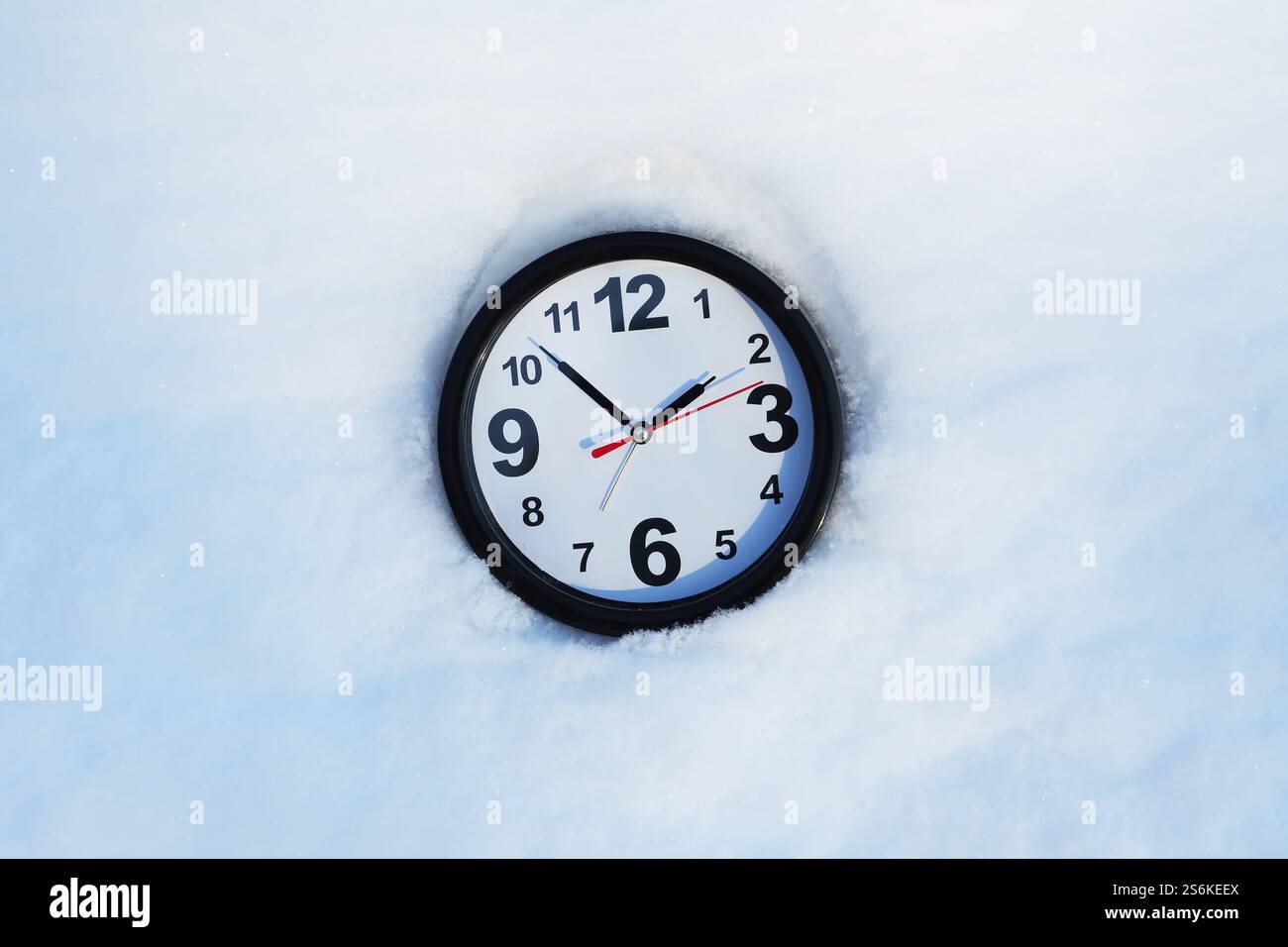Time concept. Clocks in the snow with free space Stock Photo - Alamy