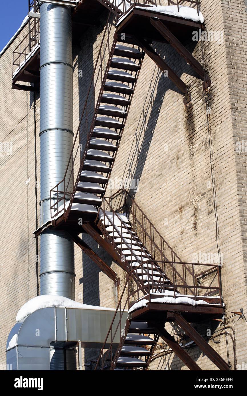 Brick wall of old factory with fire escape and metal chimney Stock ...