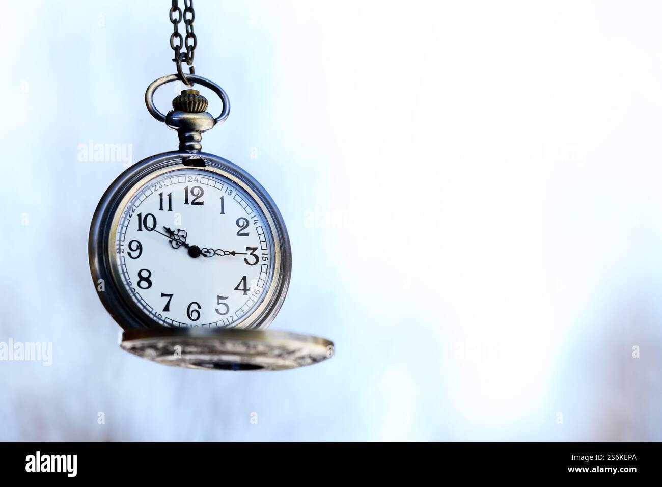 Time concept. Pocket watch hanging on an abstract nature background ...