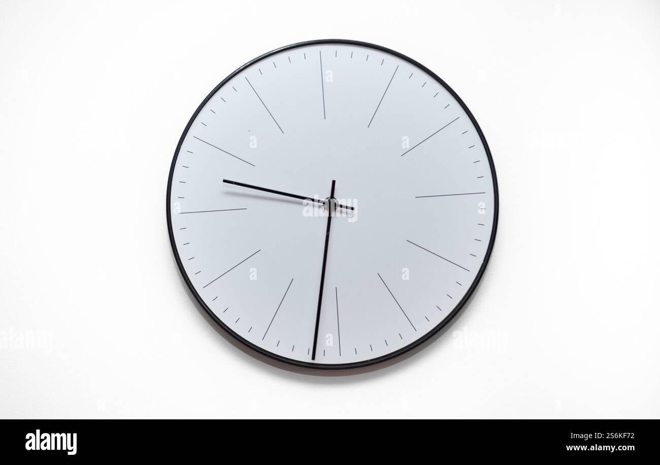 A clock with the hands on the number 3 and 9. The clock is white and ...